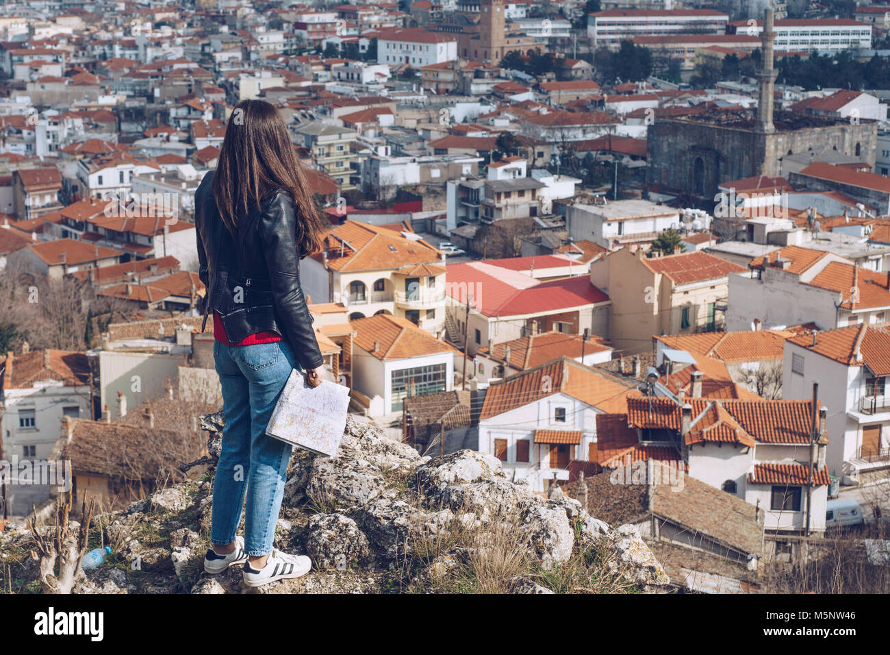 Young girl standing in front of beautiful city view. Panoramic view ...