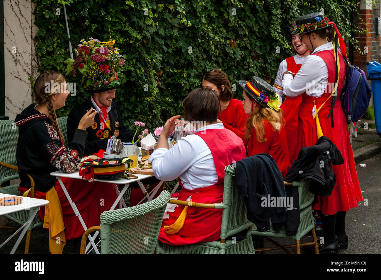 A Group Of Young Morris Dancers Eating Lunch At A Cafe During The ...