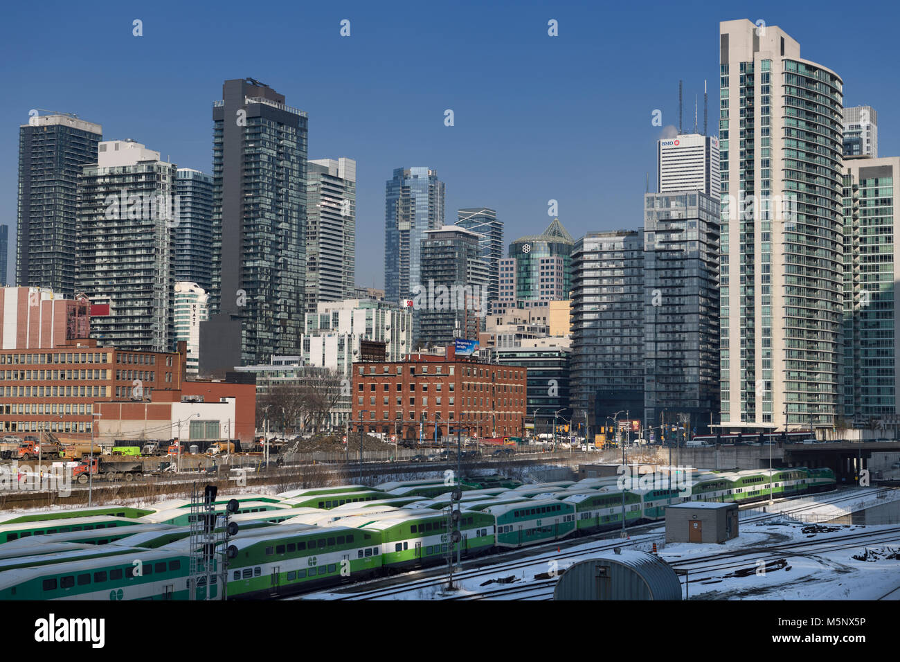 Commuter GO trains on railway tracks in Toronto with cityscape skyline ...