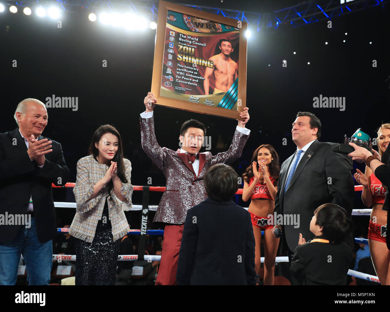 Los Angeles, USA. 24th Feb, 2018. China's boxer Zou Shiming (C) holds ...