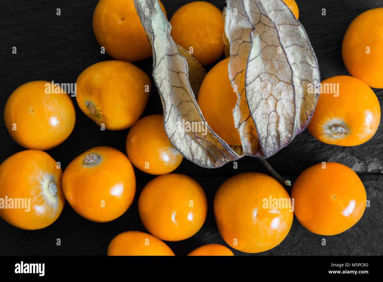 Cape Gooseberries on black rock surface background with the free pace ...