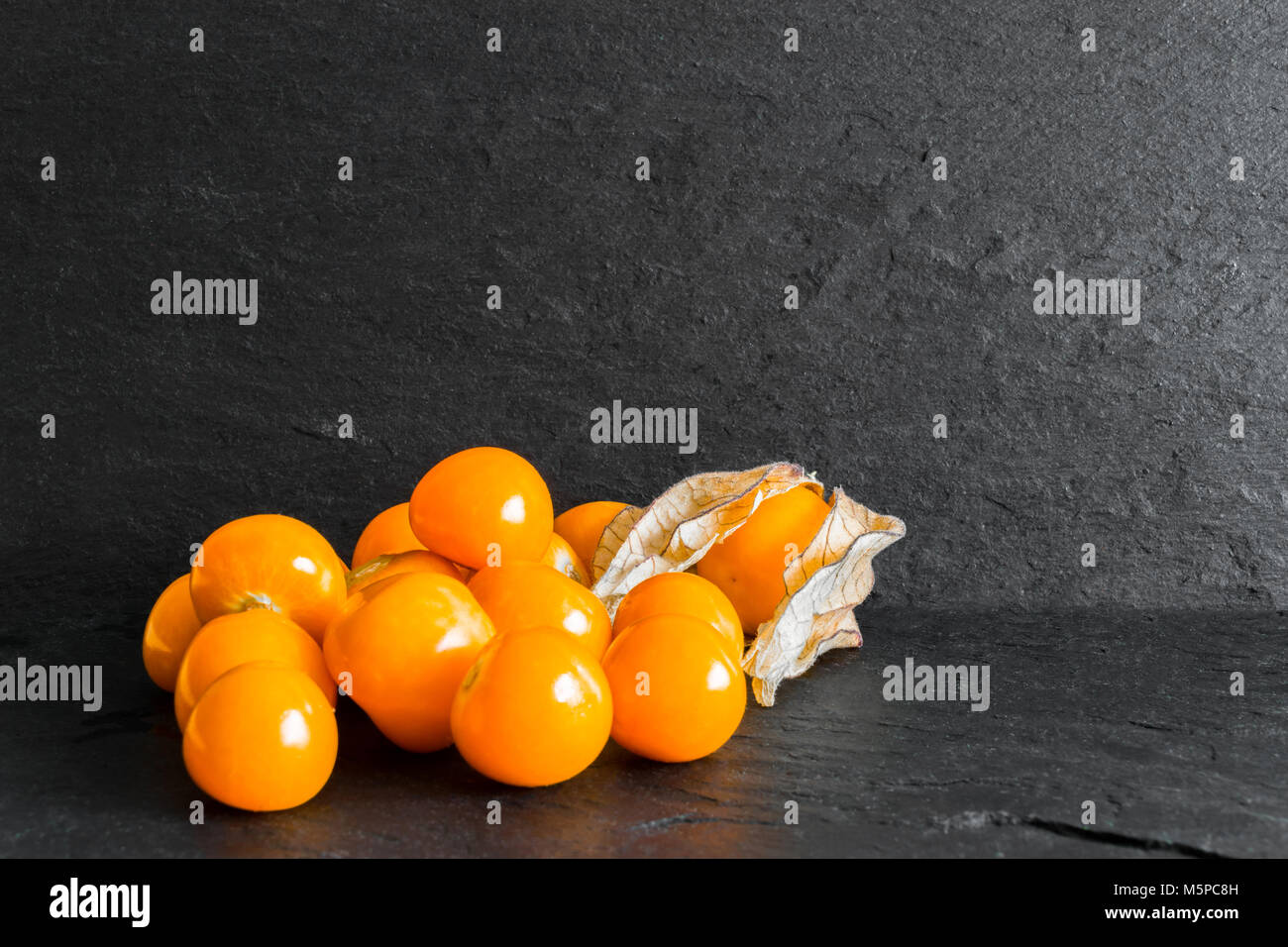 Cape Gooseberries on black rock surface background with the free pace ...