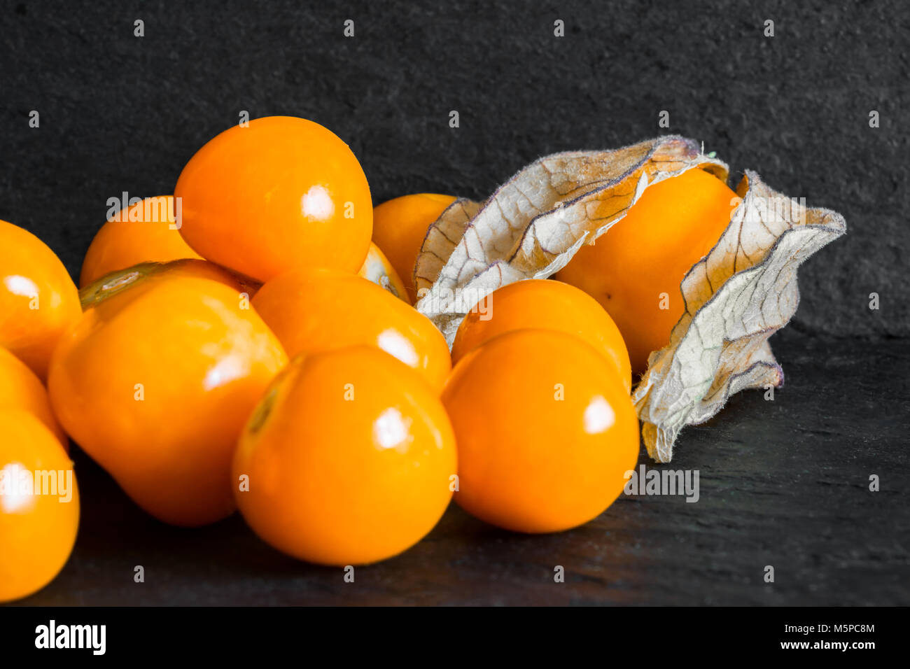 Cape Gooseberries on black rock surface background with the free pace ...