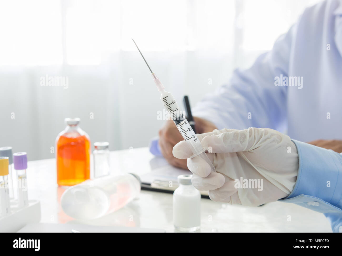 Doctor holding medical injection syringe in hospital. healthcare and ...