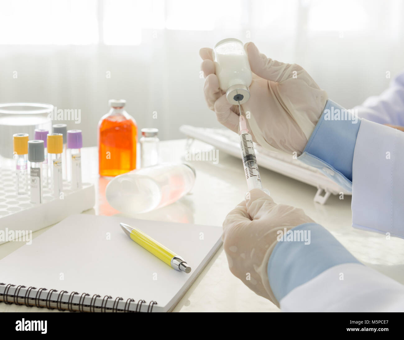 Doctor filling of a syringe with medicine from vial in hospital ...