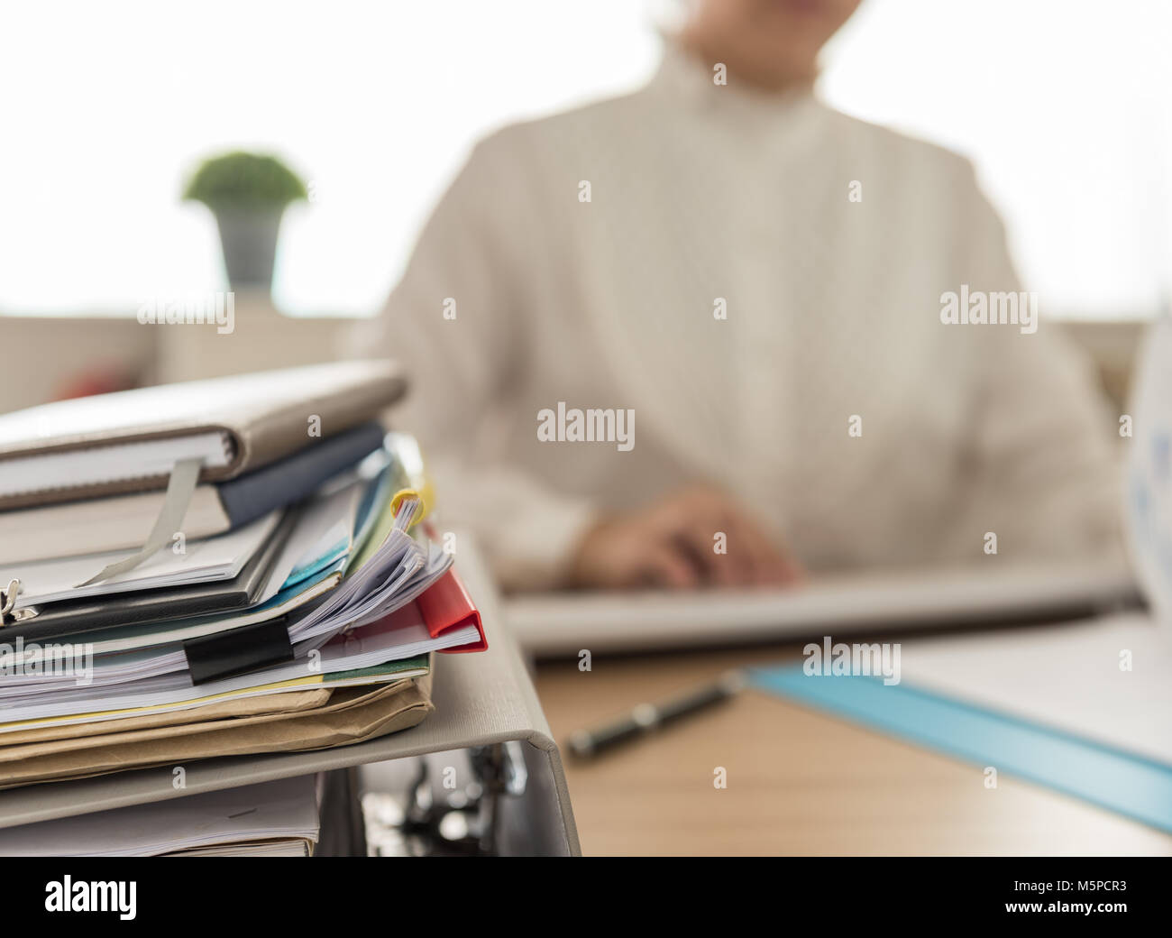 a lot of documents on desk with working women at her office Stock Photo ...