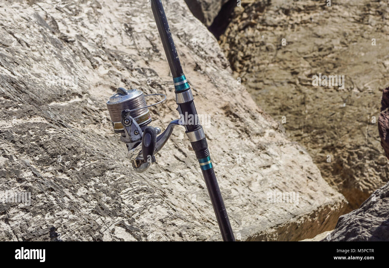 fishing rod with reel between the rocks ready to be used Stock Photo ...