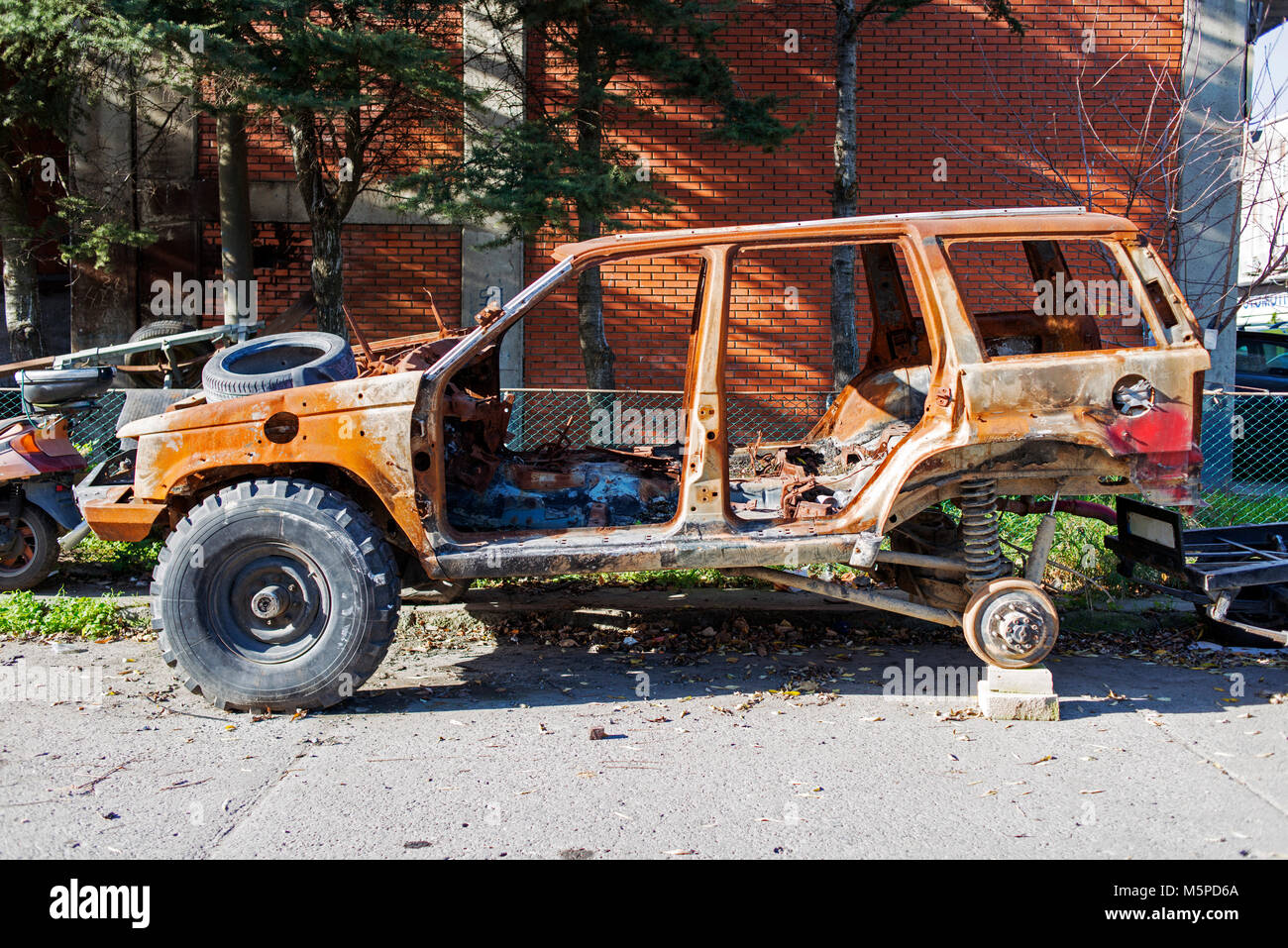 A burned rusty car in the street Stock Photo - Alamy