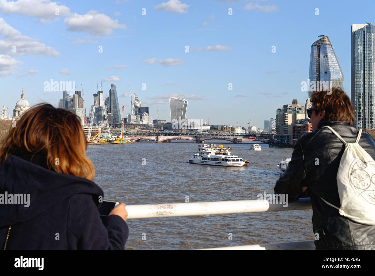 Rear view of two females looking at the skyline of the City of London ...