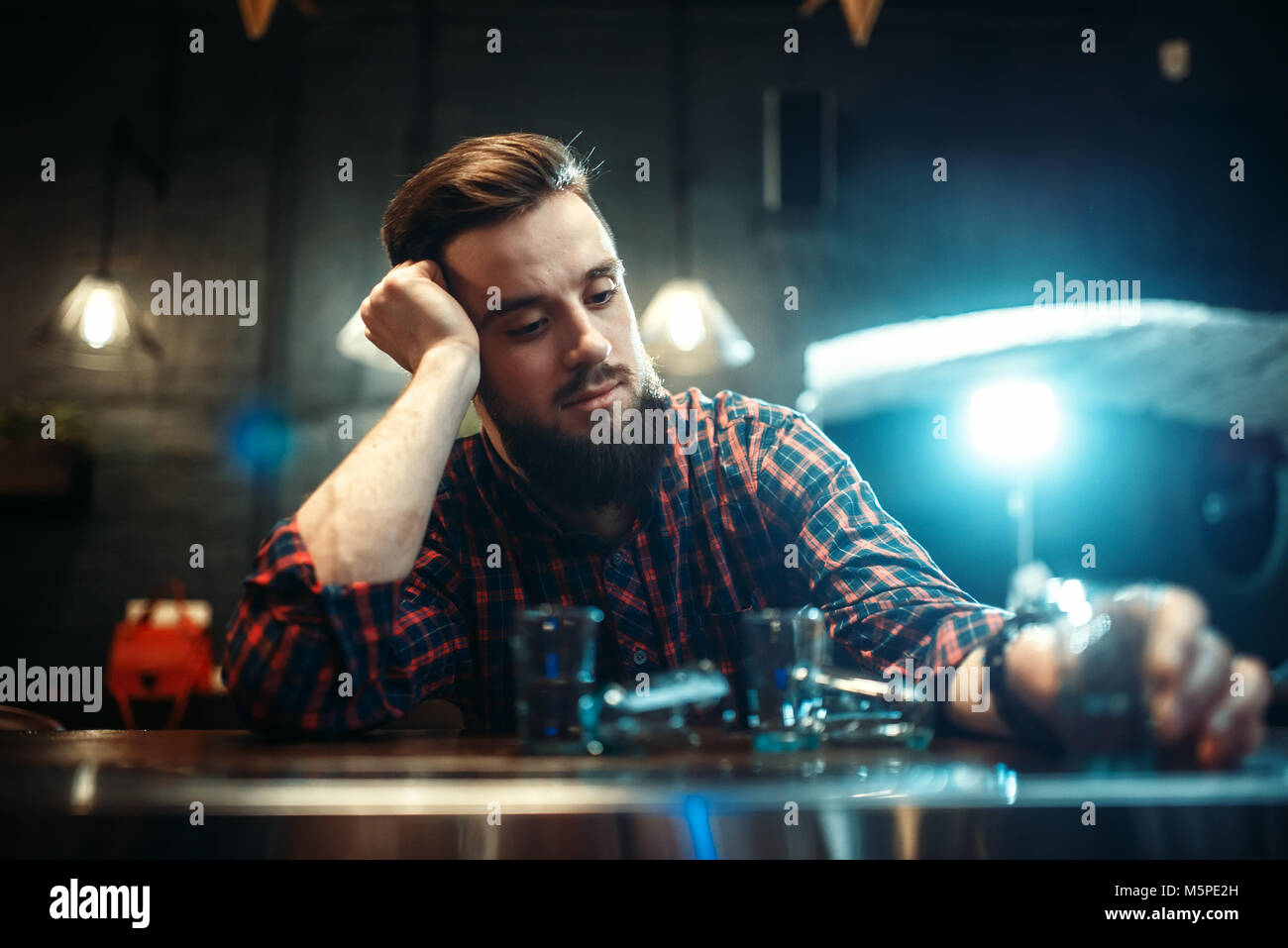 Sad man sitting at the bar counter, alcohol addiction. Male person in ...