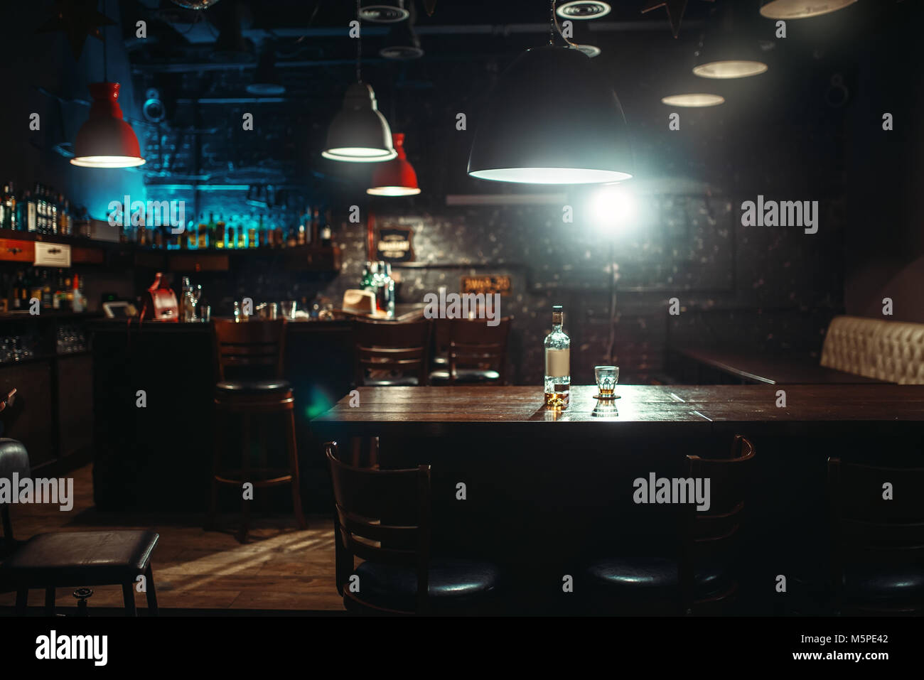 Empty pub, bottle of alcohol and glass on bar counter. Restaurant ...