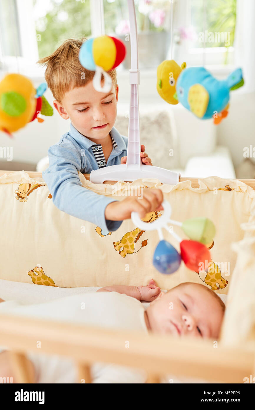 Boy as a brother caring for newborn baby in the baby bed Stock Photo ...
