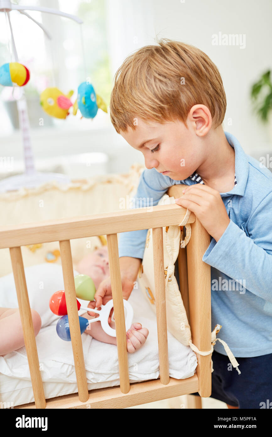 Boy as a caring brother at the baby bed with newborn baby Stock Photo ...