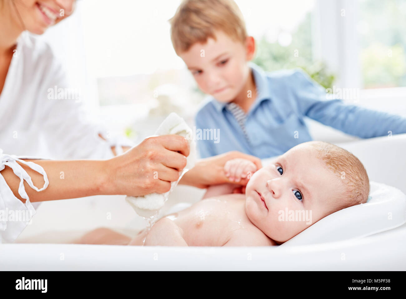 Baby is being washed carefully by the mother in the bathtub Stock Photo ...