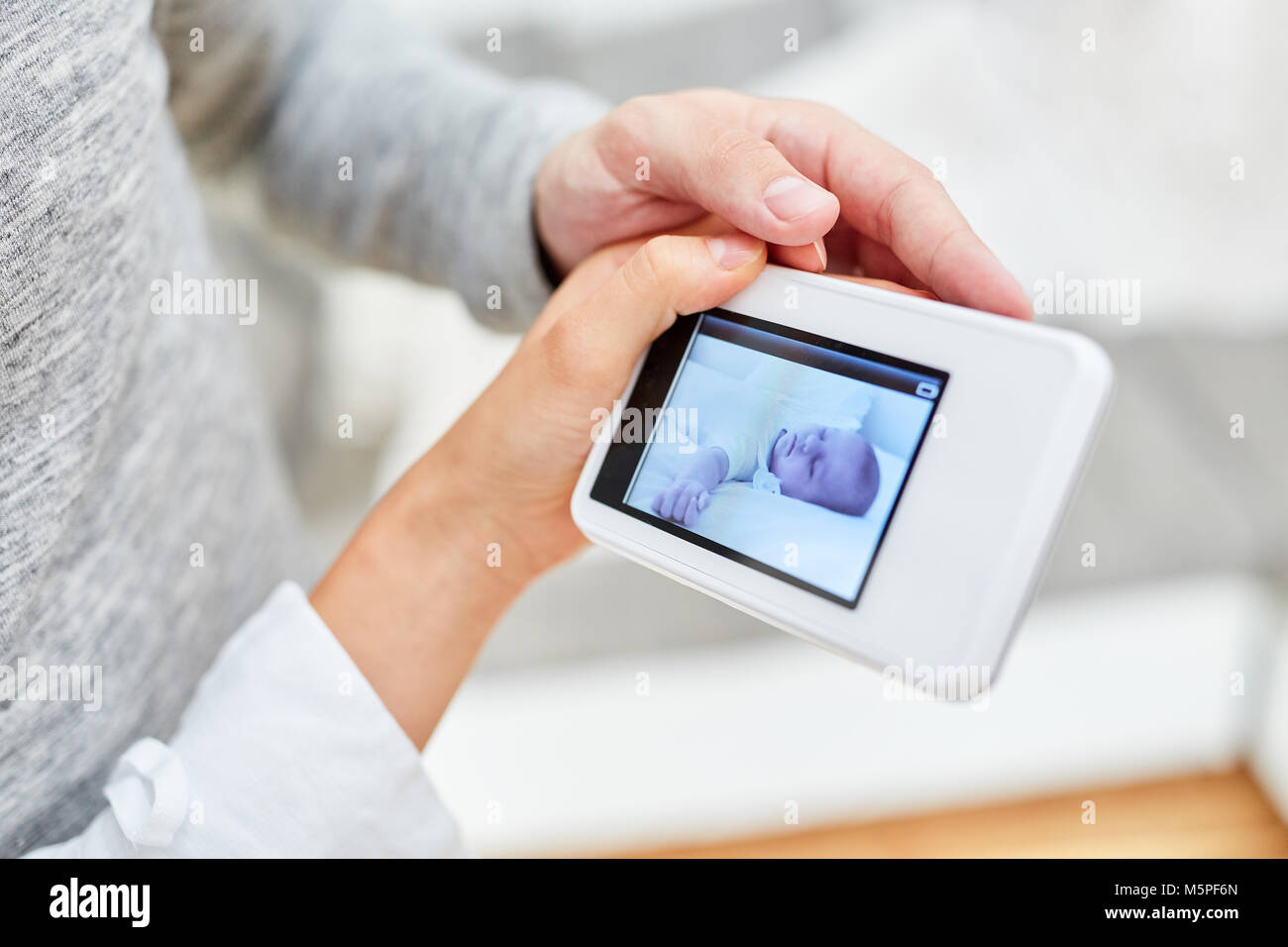 Parents look at a baby monitor with camera for video surveillance of ...