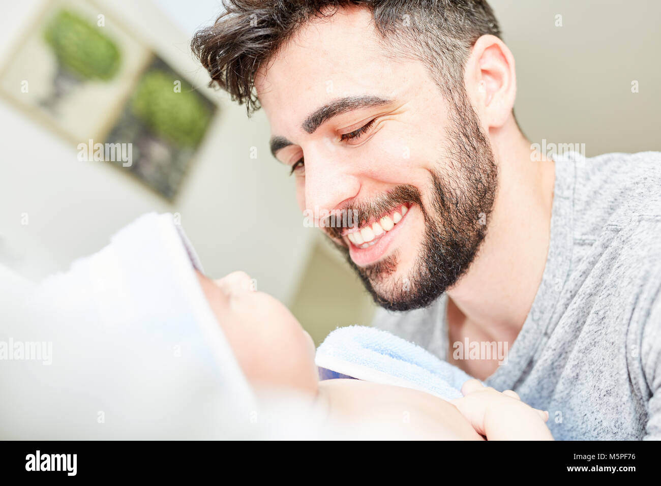 Happy and proud father looks lovingly in the face of his baby Stock ...