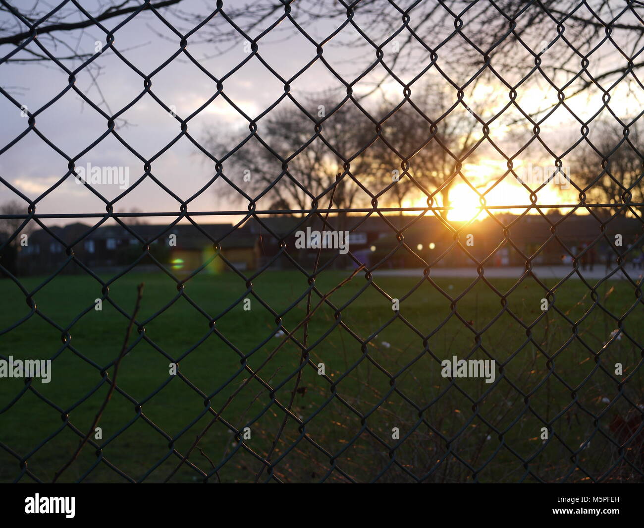 Sunset over playing field, twilight scene with playground grass and ...