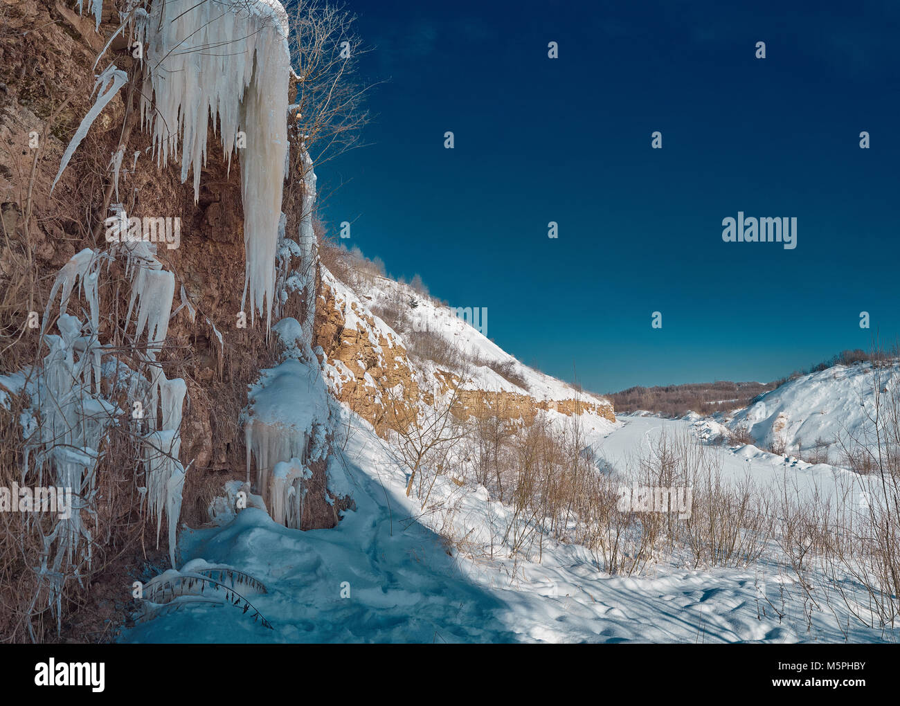 Huge blocks of ice hanging from the cliff. The beauty of the wild Stock ...