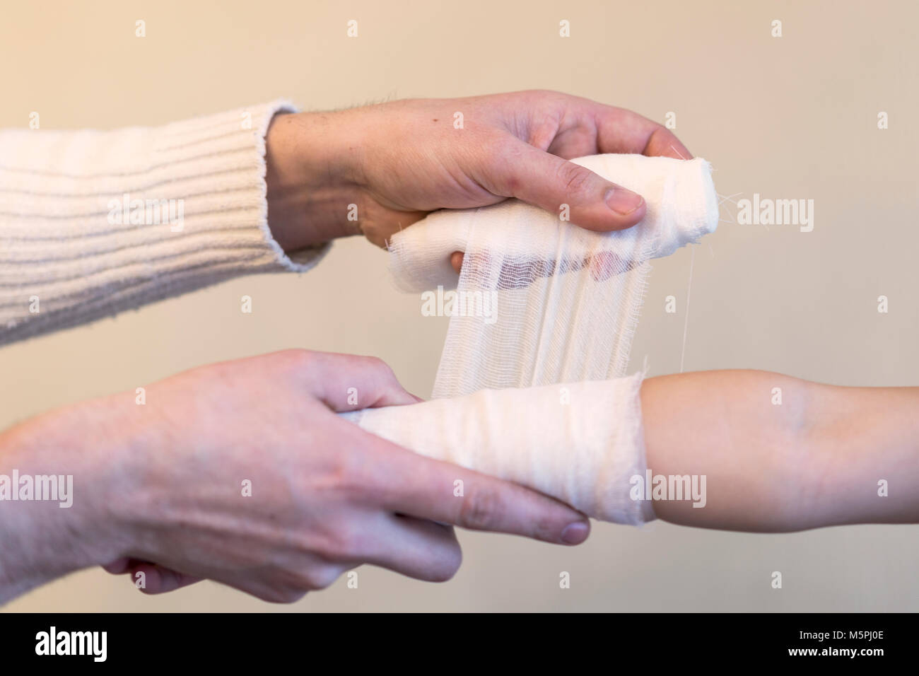 Pediatrician doctor bandaging child's arm Stock Photo - Alamy