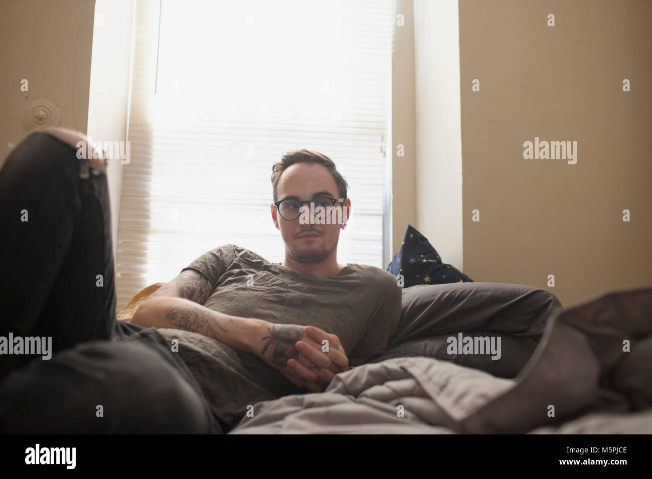 young man lying on bed Stock Photo - Alamy