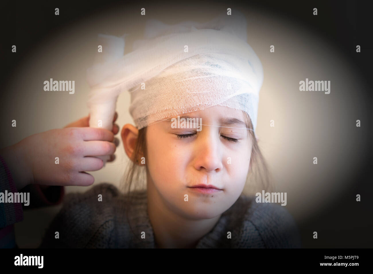 Pediatrician doctor bandaging child's head. vignetting Stock Photo - Alamy
