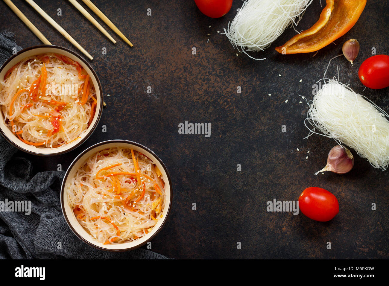 Funchoza salad with rice noodles with paprika, tomatoes and pepper on a ...