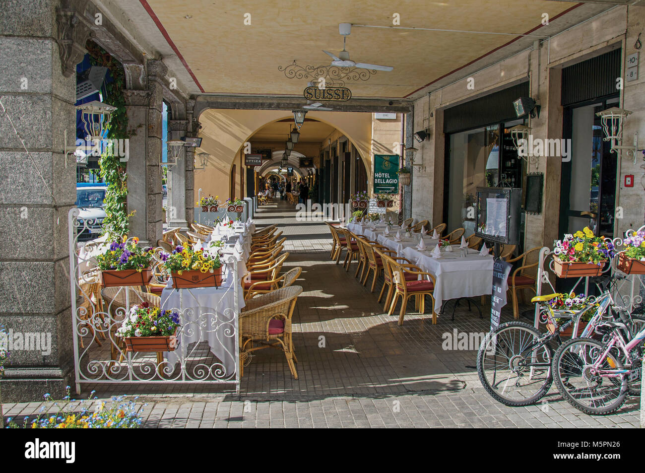 Como, Italy. View of restaurant tables and chairs on pedestrian walkway ...