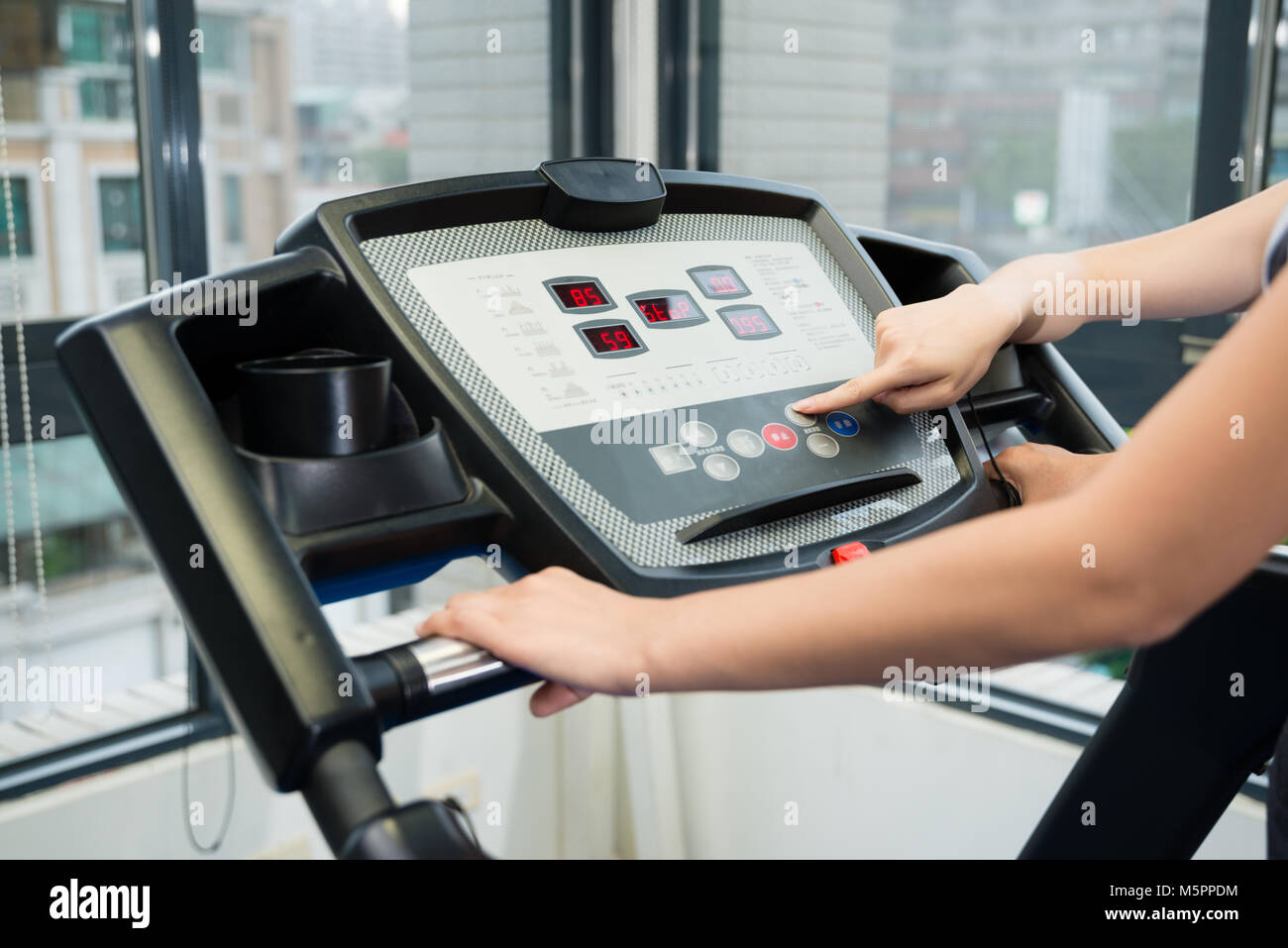 Instructor is pointing to the treadmill running machine panel and teach ...