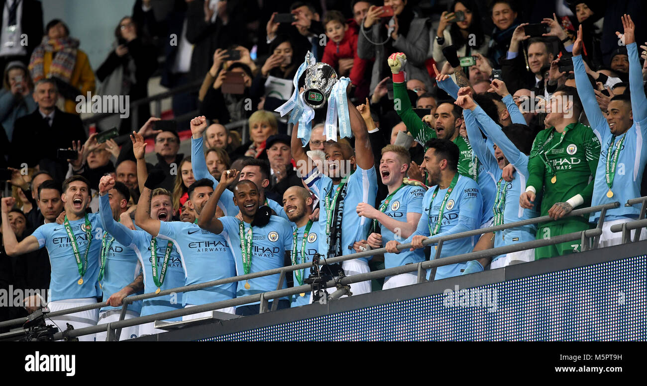 Manchester City's Vincent Kompany celebrates with the trophy alongside ...
