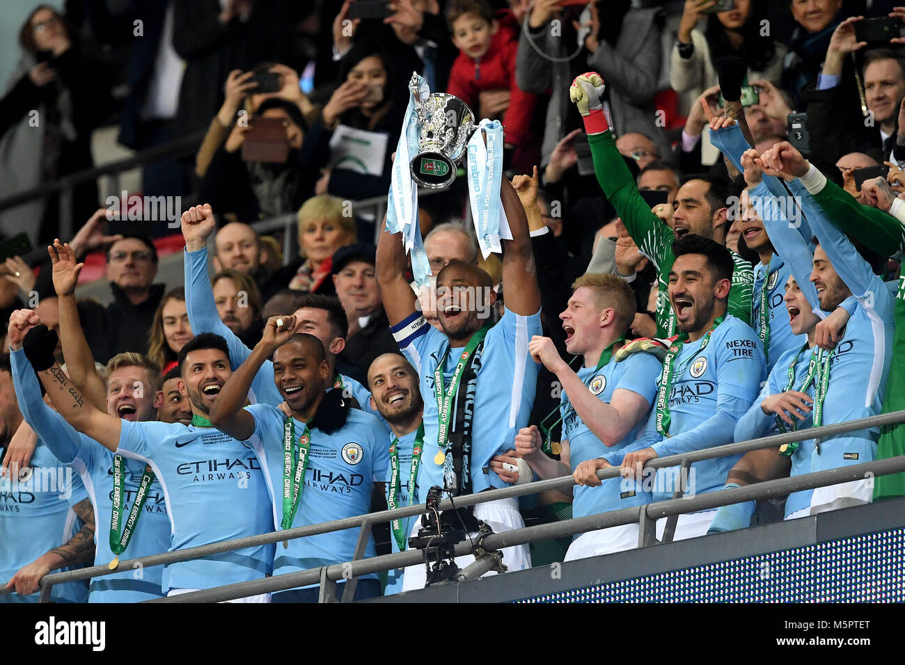 Manchester City's Vincent Kompany celebrates with the trophy alongside ...