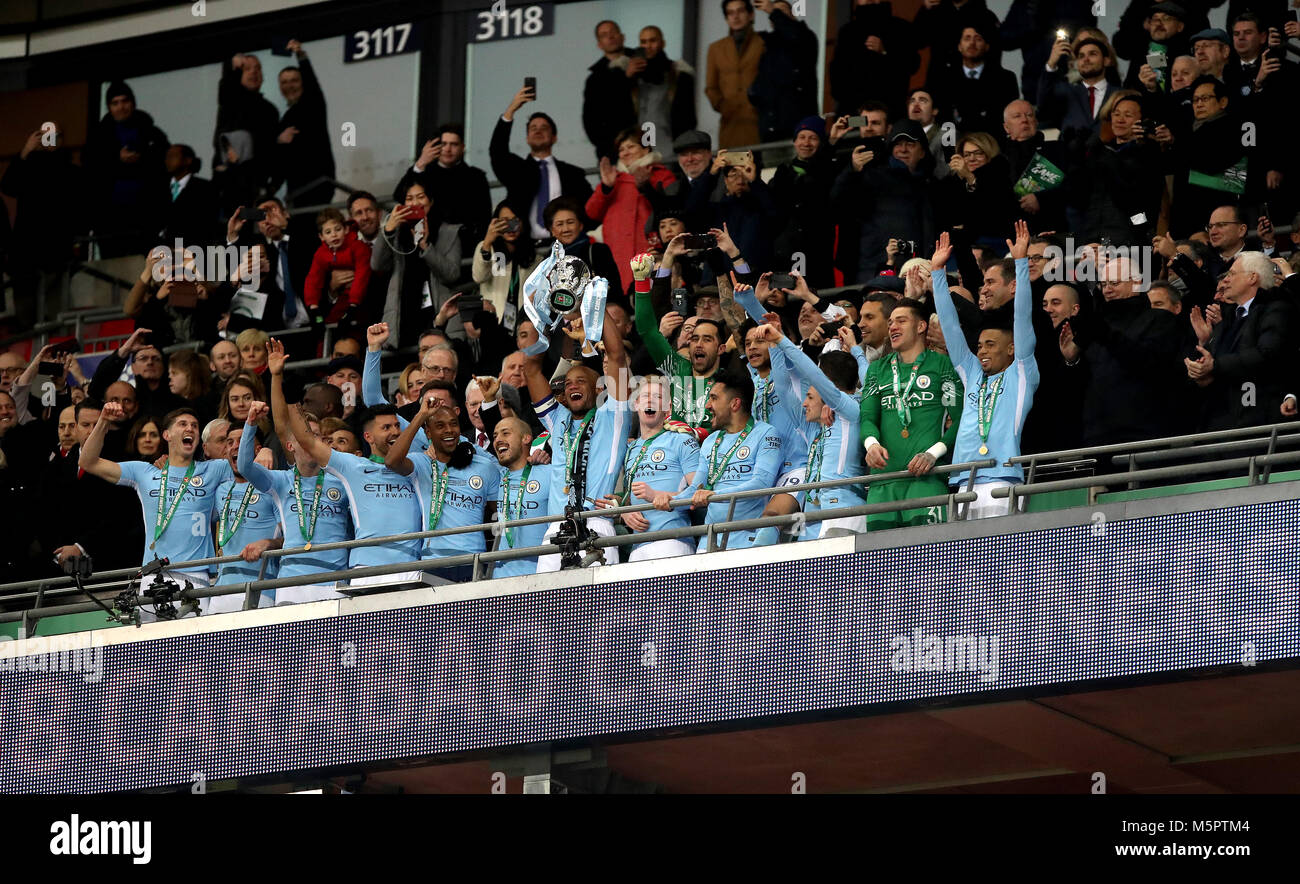 Manchester City's Vincent Kompany celebrates with the trophy alongside ...