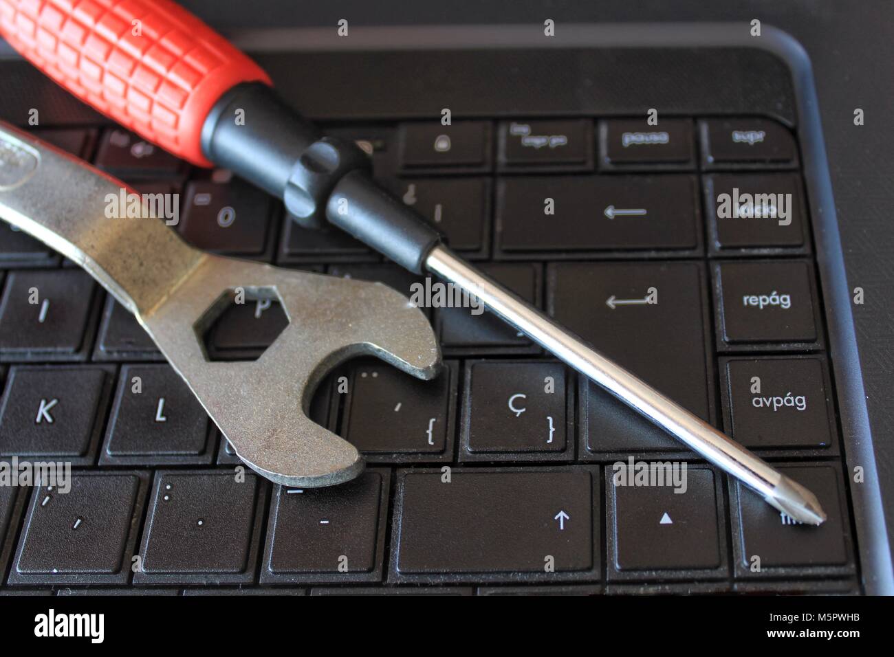 Tools on black keyboard laptop Stock Photo - Alamy