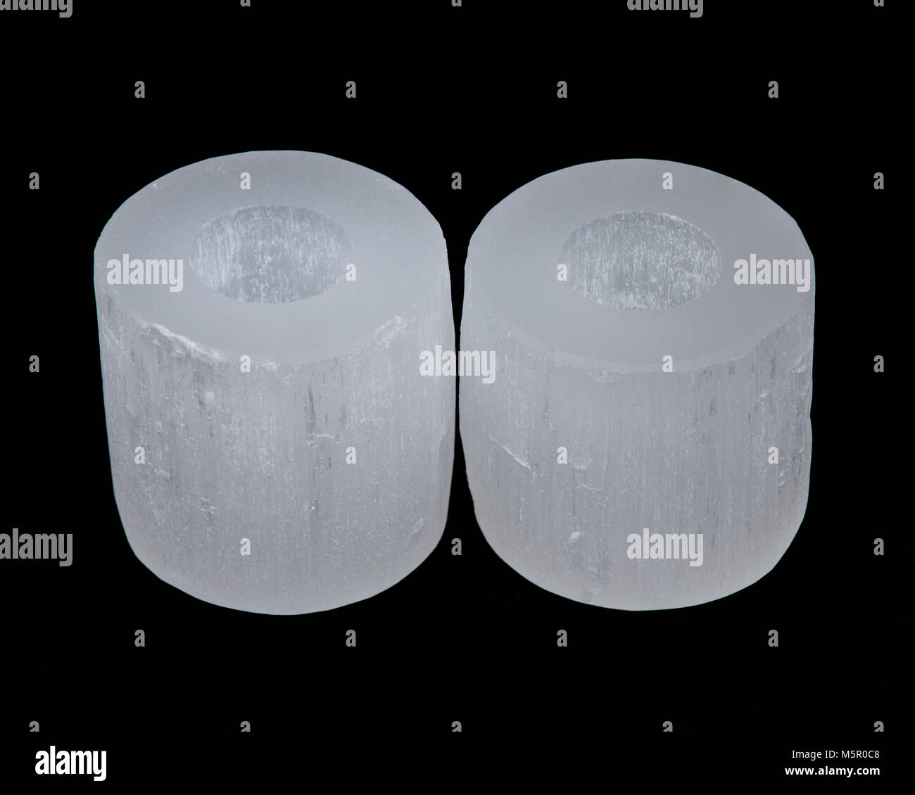 White selenite cylinder tea light holder on black background Stock ...