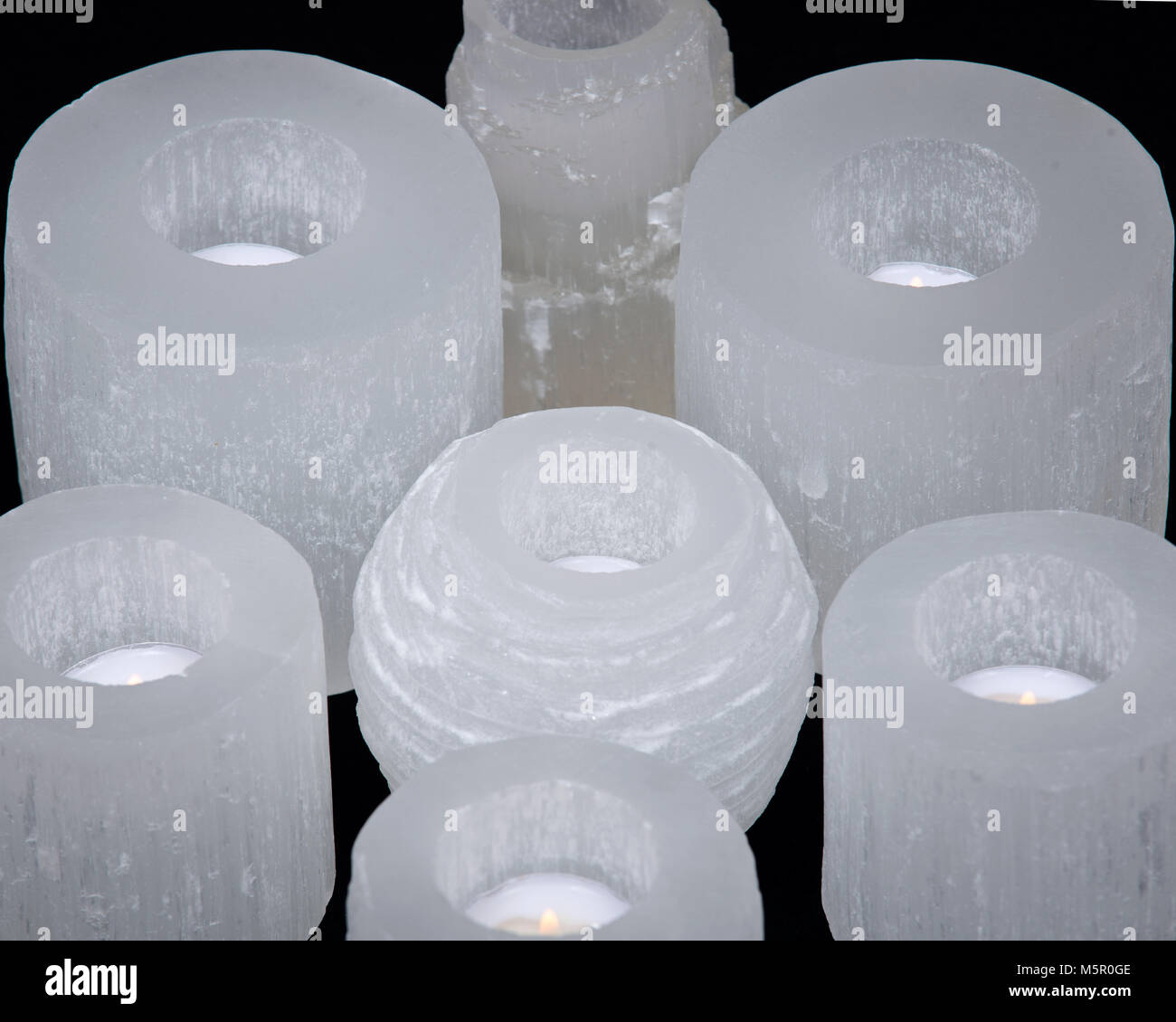 White selenite cylinder tea light holder on black background Stock ...