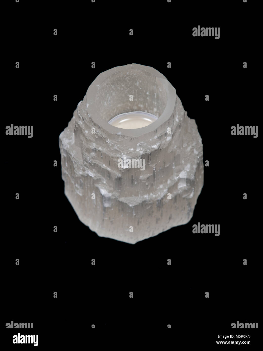 White selenite everest carved tea light holder on black background ...