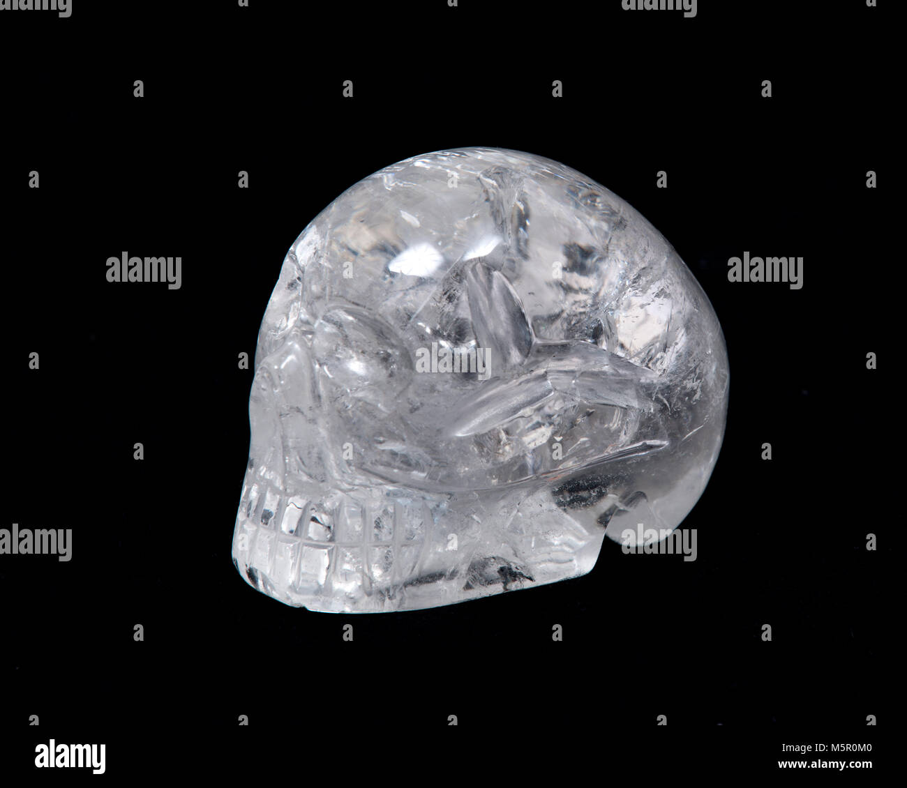 Clear quartz skull with rainbow on black background Stock Photo - Alamy