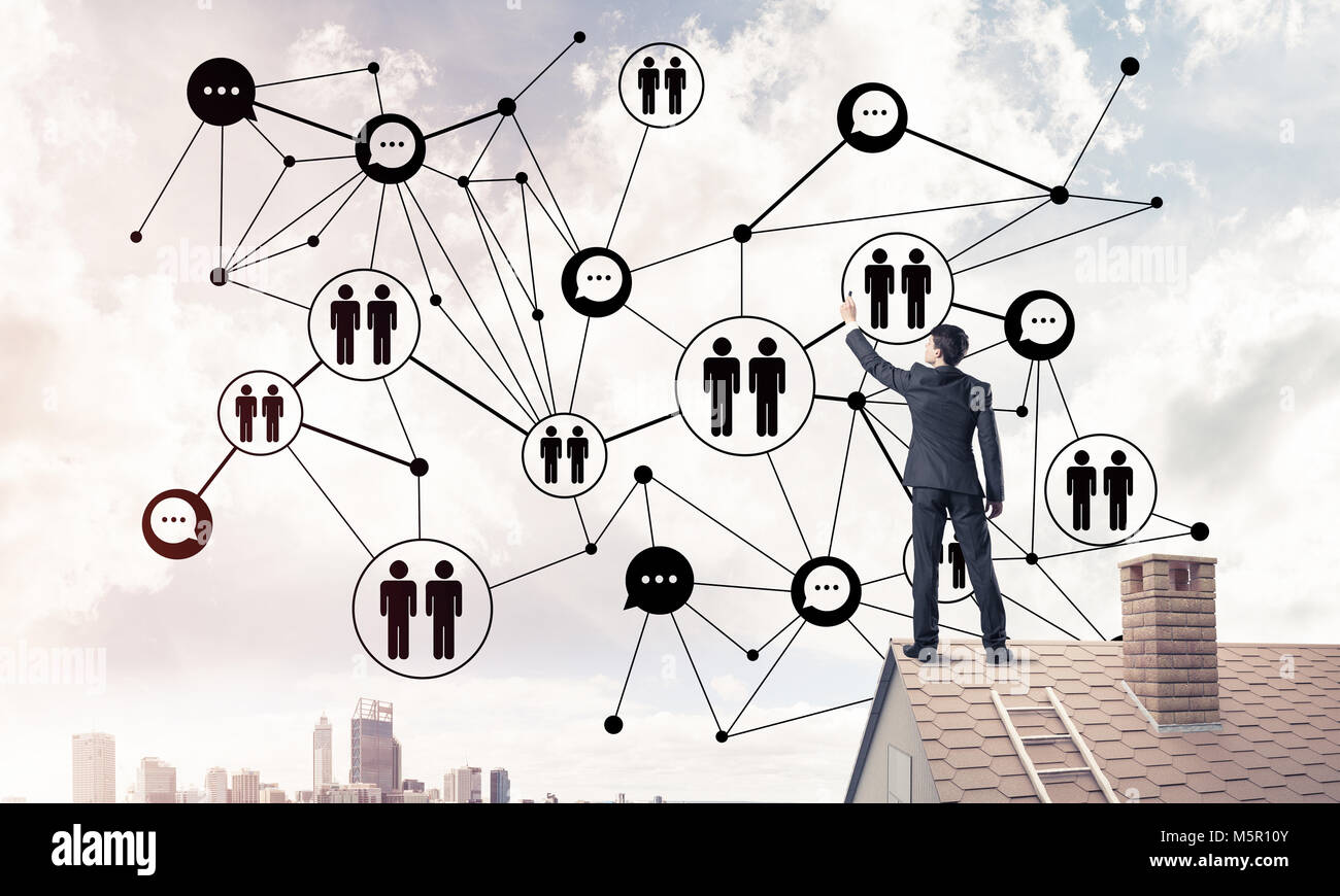 Businessman on house roof presenting networking and connection c Stock ...