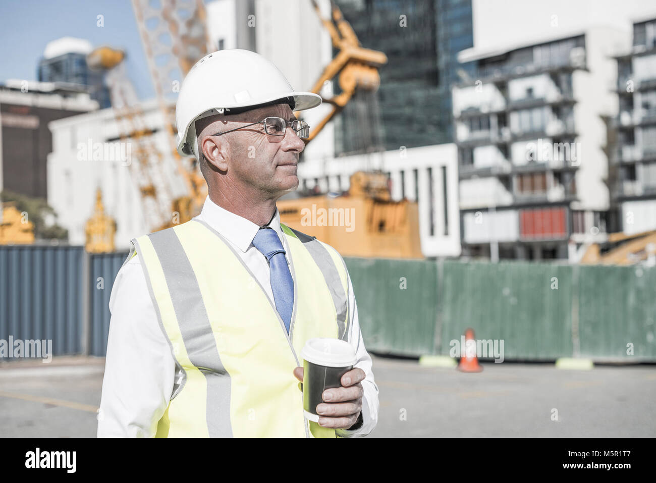 Engineer builder on construction site at sunny day with coffee i Stock Photo - Alamy