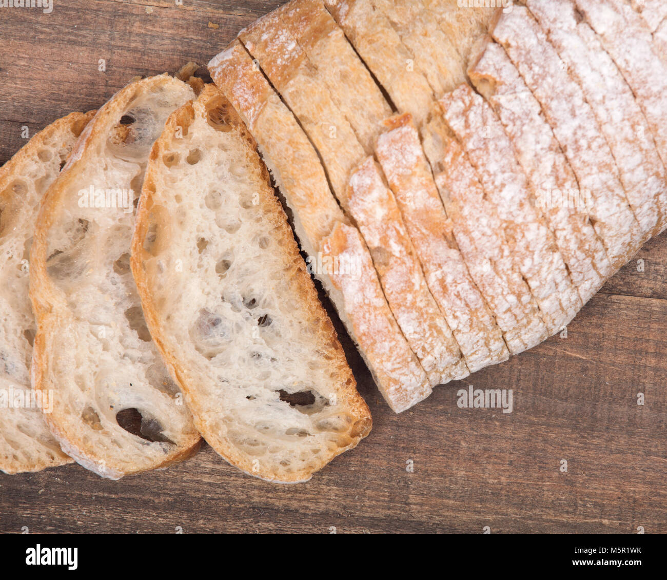 Sliced crusty ciabatta organic italian bread on wooden vintage tray ...