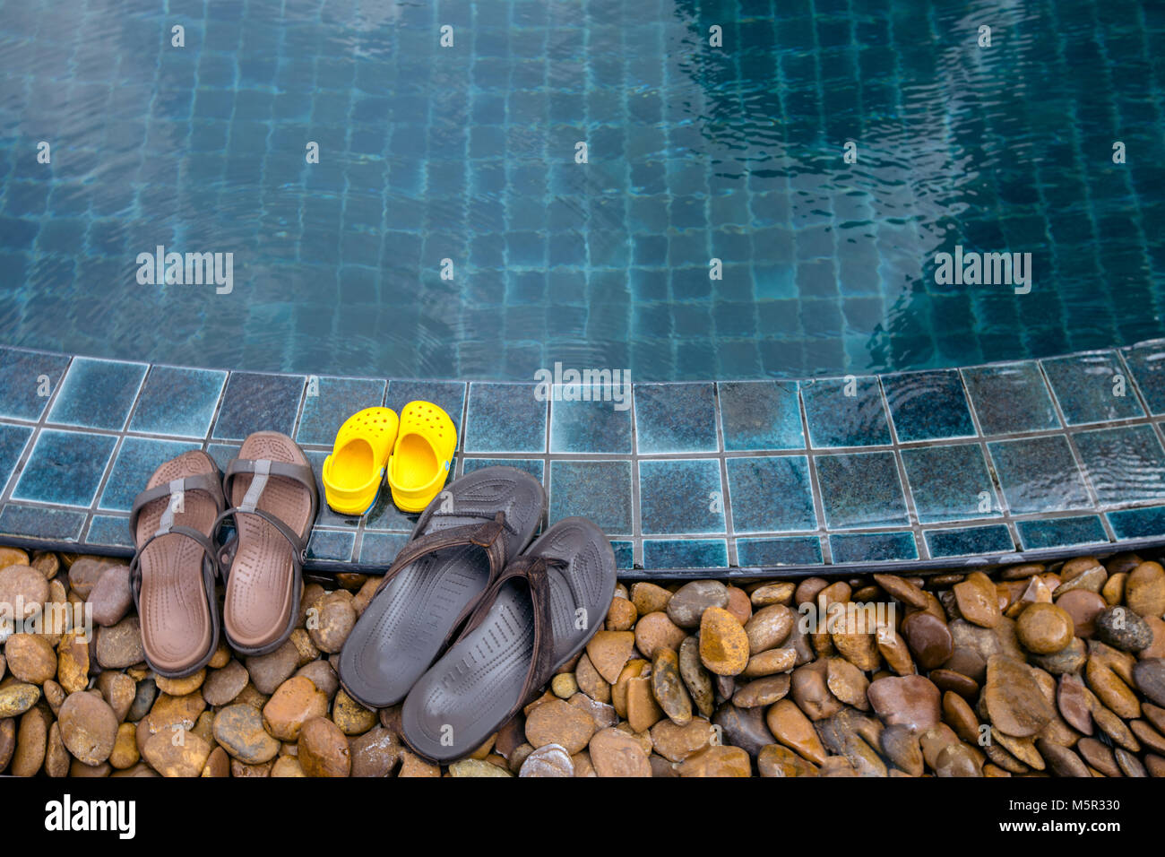 Slippers on edge of swimming pool Stock Photo - Alamy
