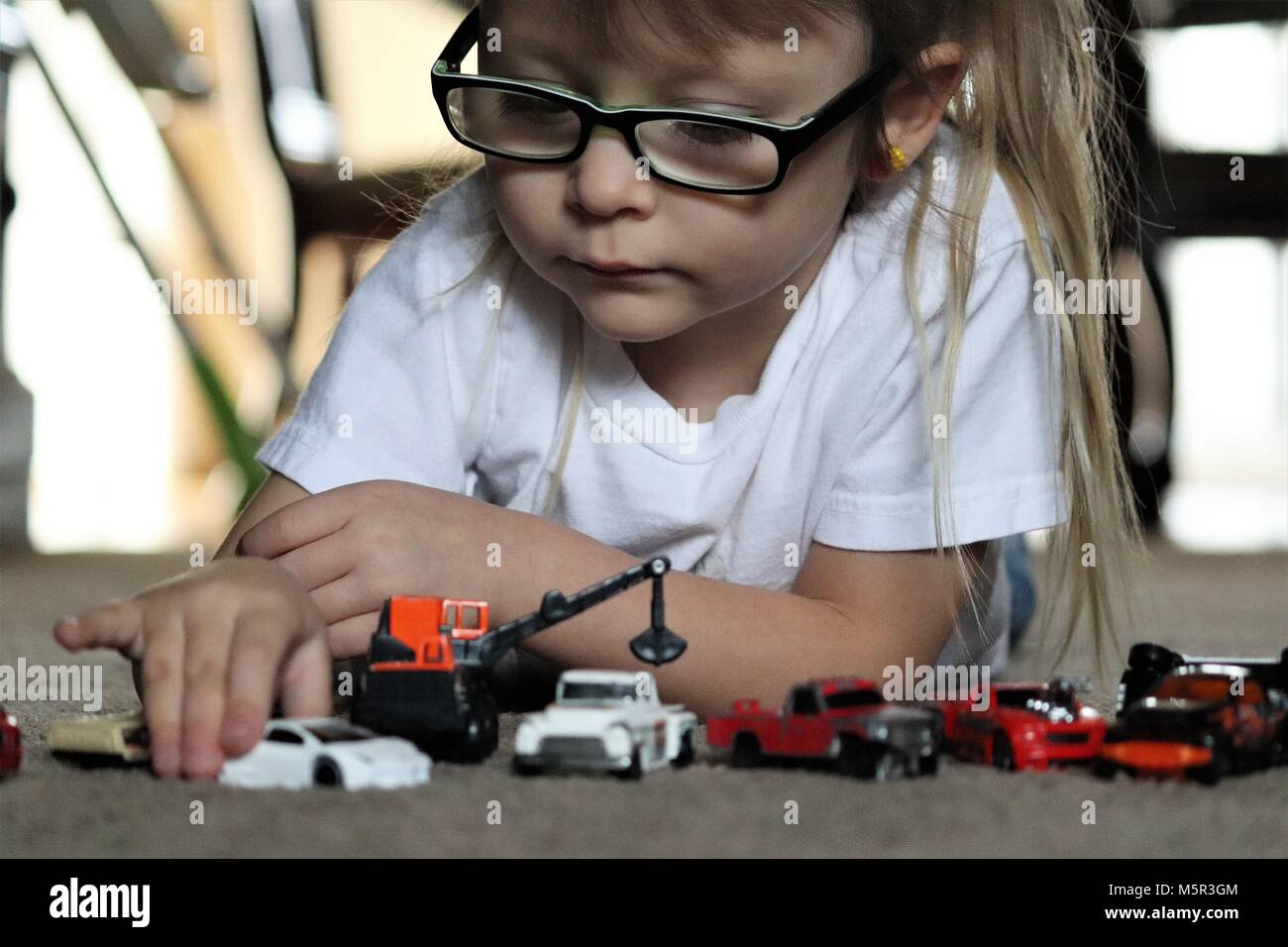 Girl enjoys playing with her toy cars Stock Photo - Alamy