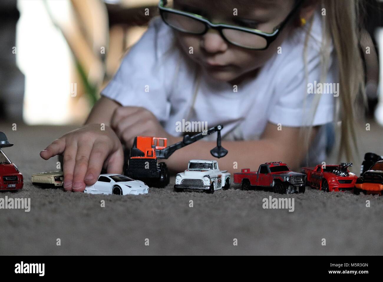 Girl enjoys playing with her toy cars Stock Photo - Alamy