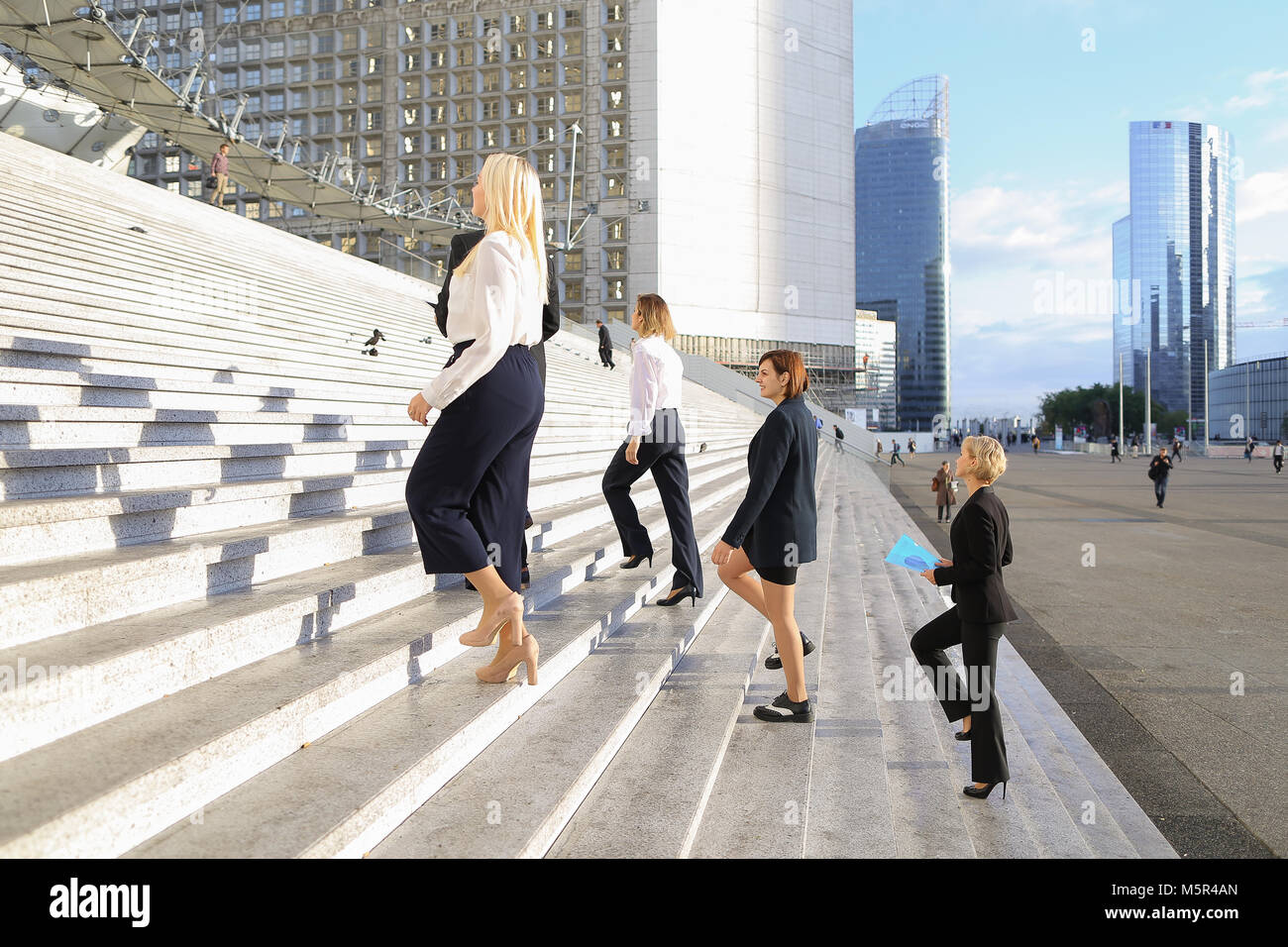 Satisfied business employees going up stairs in La Defense Paris Stock ...