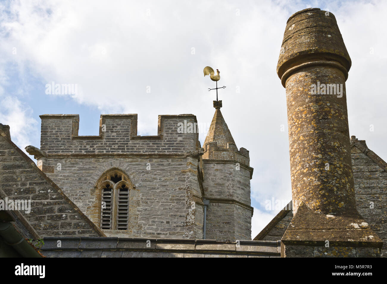 the church tower, weather vane, roof tops and stone chimney of St ...