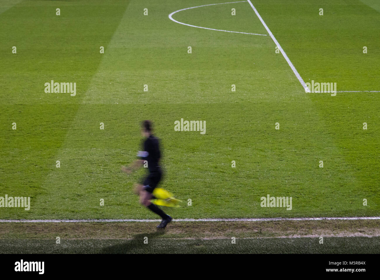 A referee runs along the side of the pitch, keeping an eye out for off ...