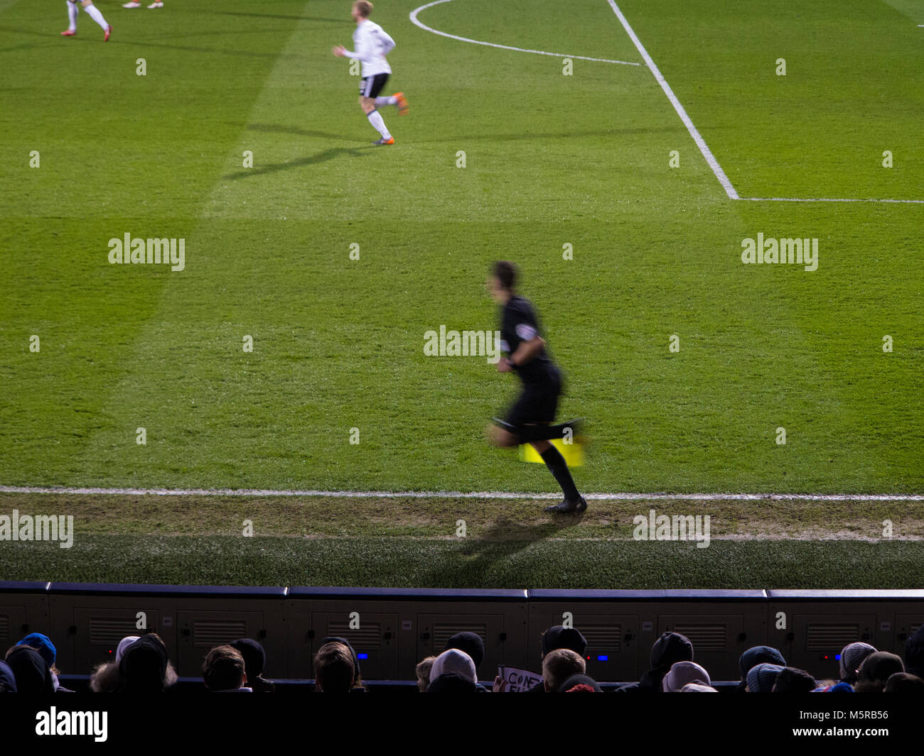 A referee runs along the side of the pitch, keeping an eye out for off ...