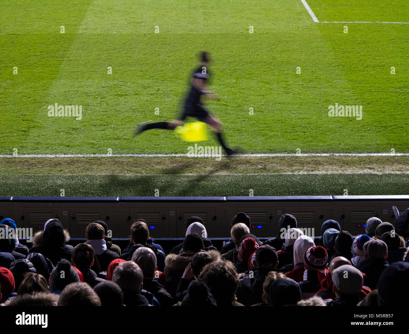 A referee runs along the side of the pitch, keeping an eye out for off ...