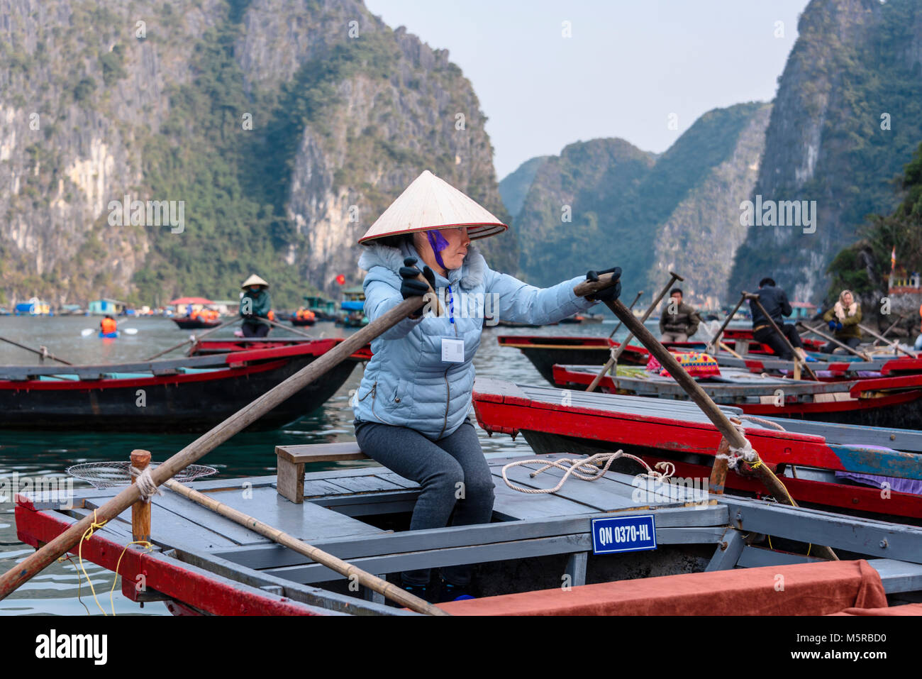 Vietnamese woman wearing traditional bamboo conical hat in a rowing ...