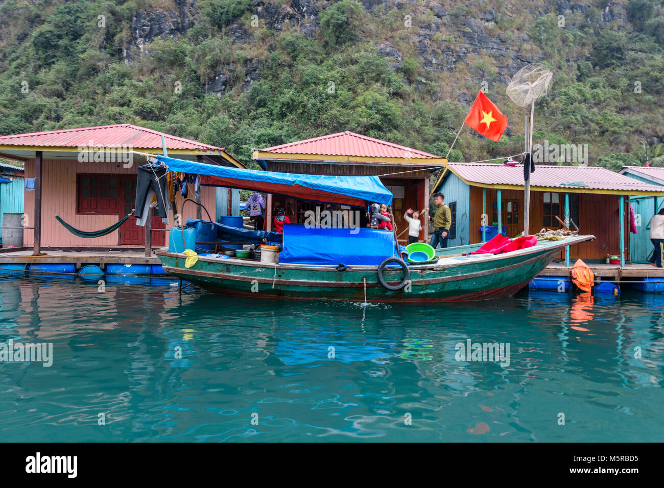 Fishing boat outside floating houses at the Cua Van floating village ...