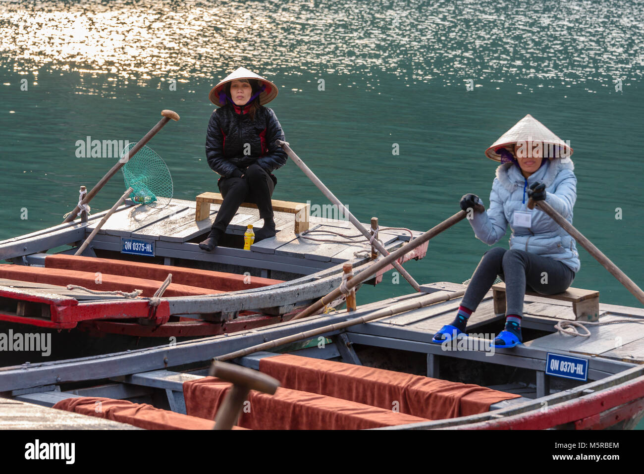 Vietnamese women wearing traditional bamboo conical hats in a rowing ...